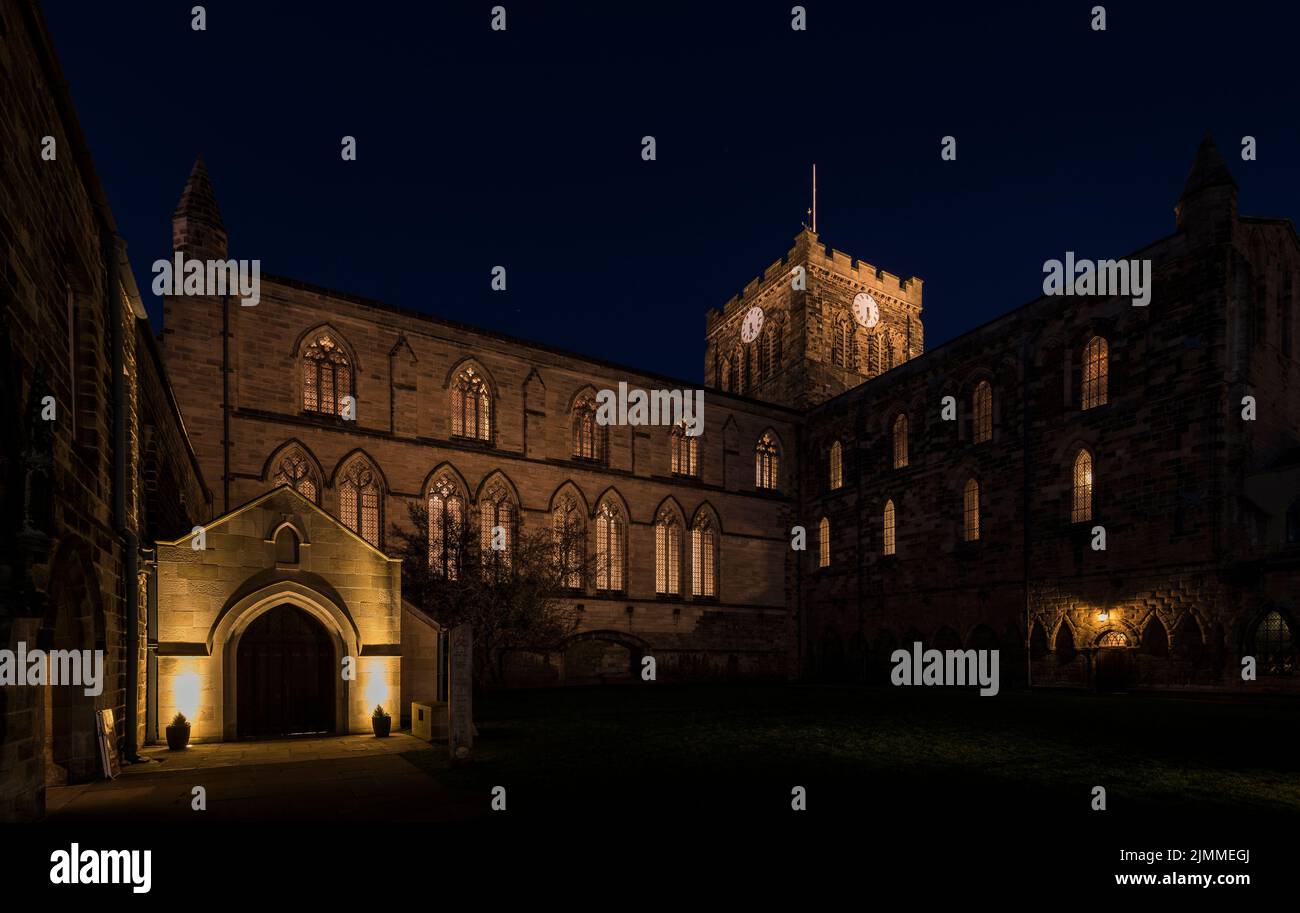 Night time image of Hexham Abbey floodlit against a dark blue sky with ...