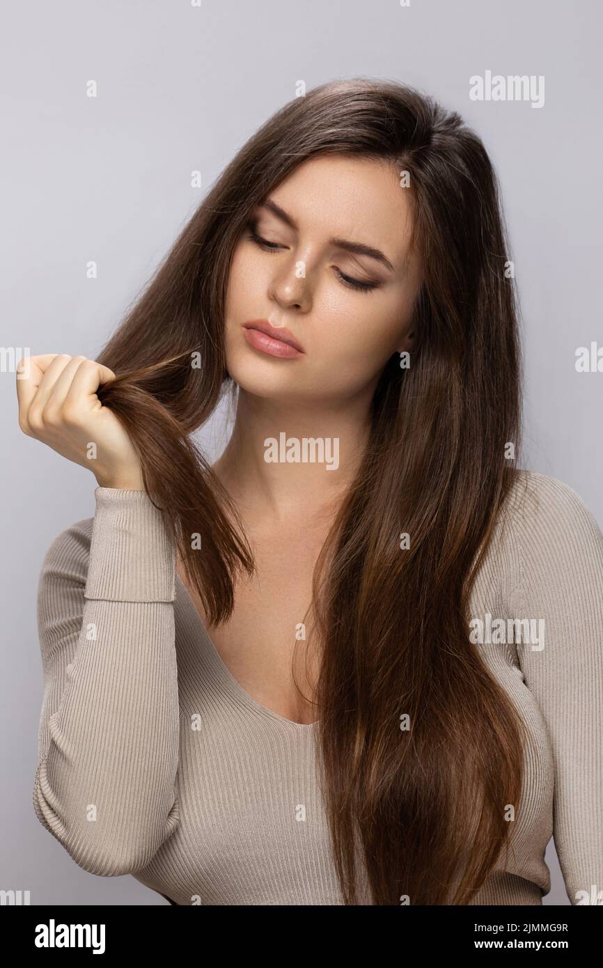 Young woman is upset with a bad condition of her hair Stock Photo - Alamy
