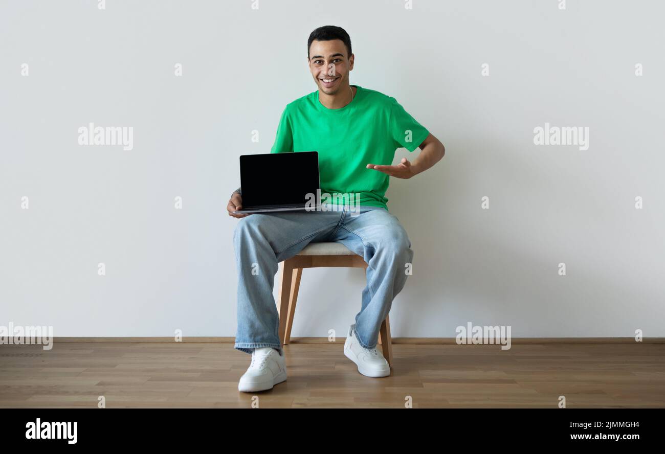 Website advertisement. Excited arab guy showing blank computer screen ...