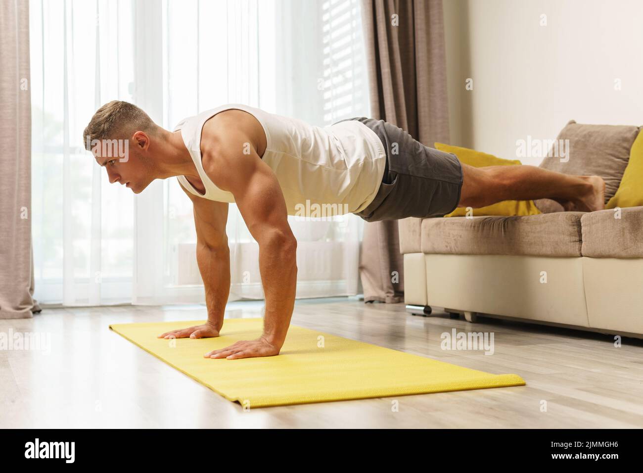 Muscular man doing push-ups during home workout Stock Photo - Alamy