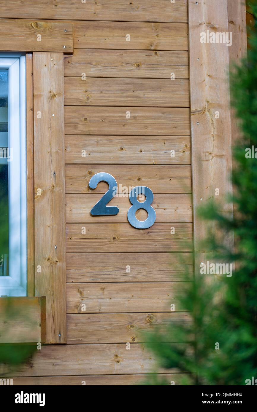 Metal house number 28 on a wooden wall background on the street in ...
