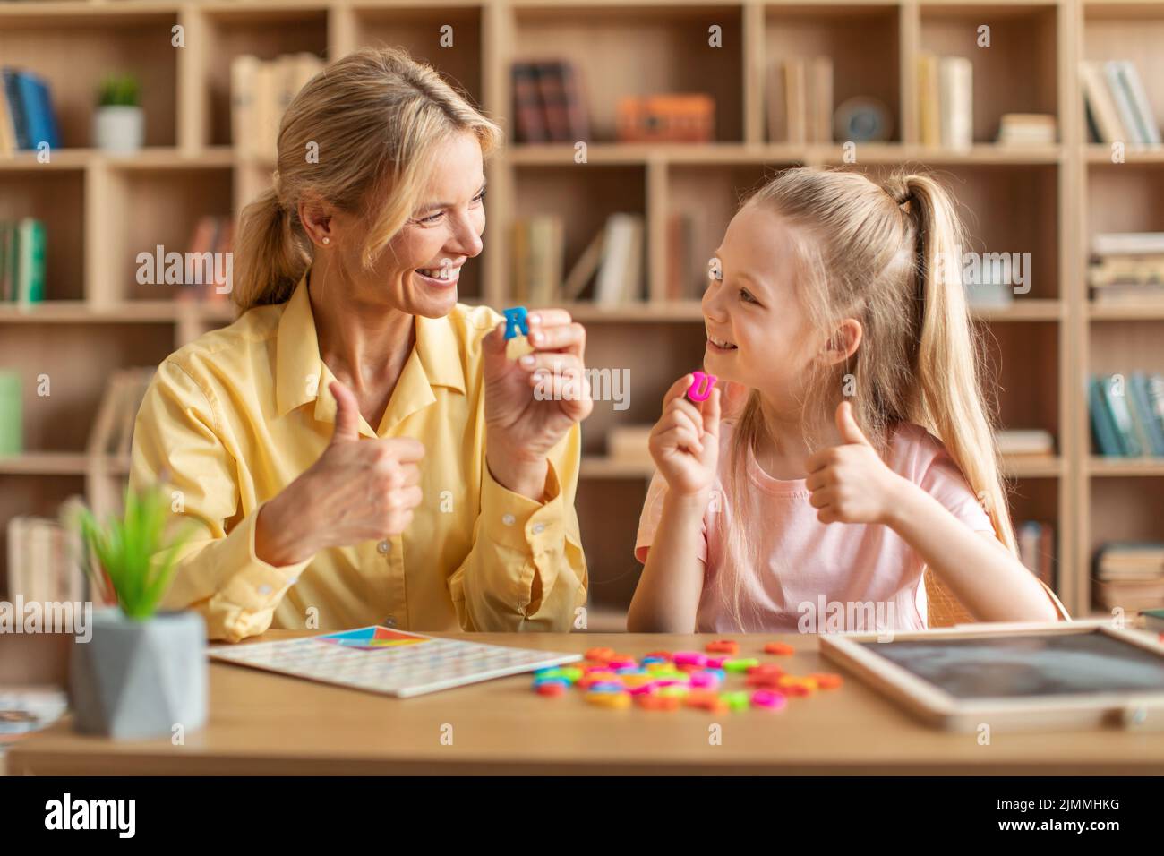 Friendly speech therapist curing child's problems, cute girl learning ...