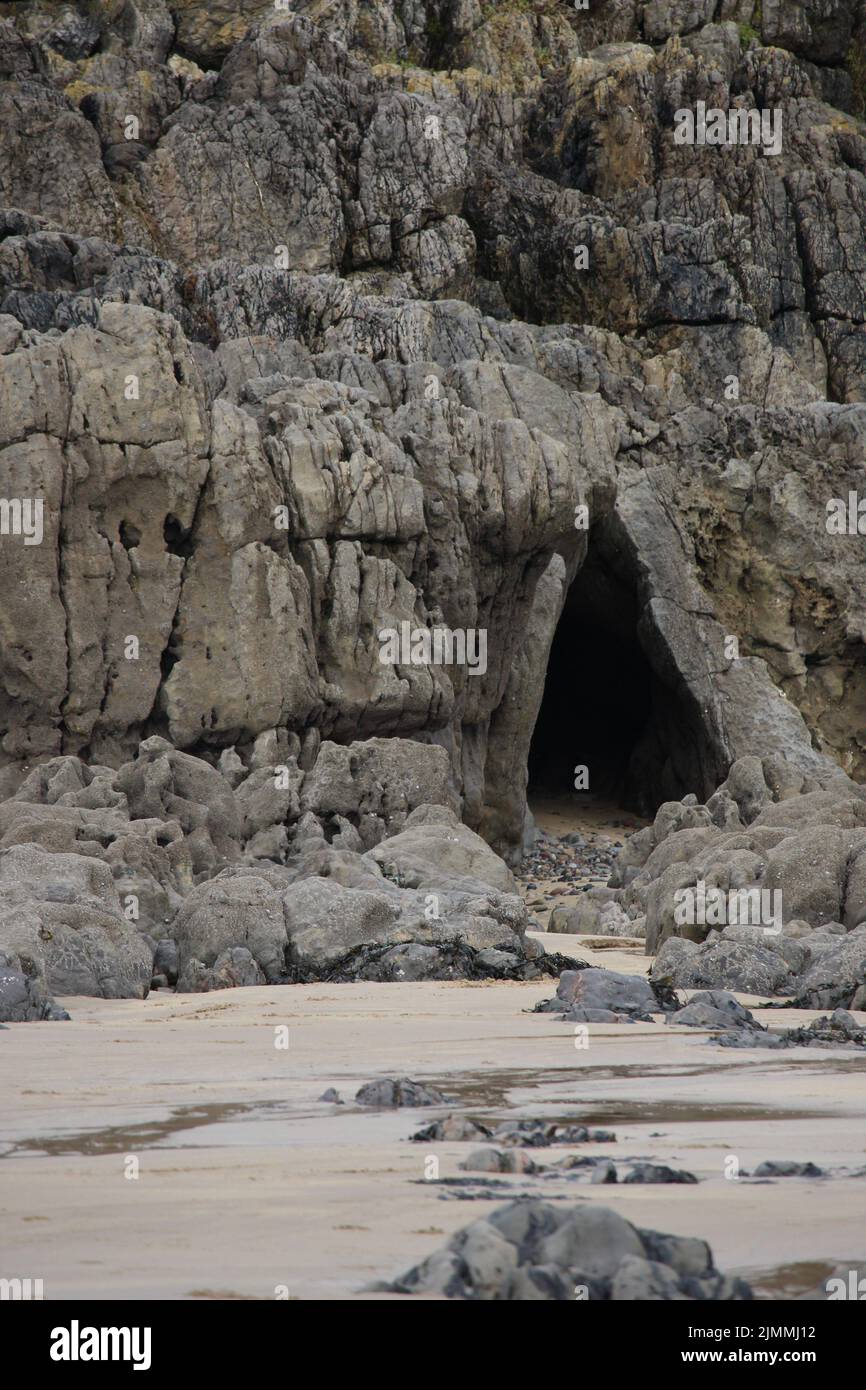 A photograph of an eerie cave entrance on a beach Stock Photo - Alamy
