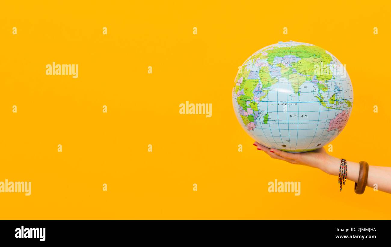 Side view hand holding globe with copy space Stock Photo - Alamy