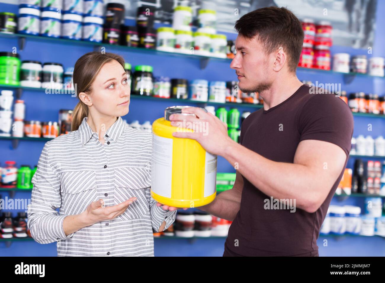 Young people discussing in shop interior Stock Photo - Alamy