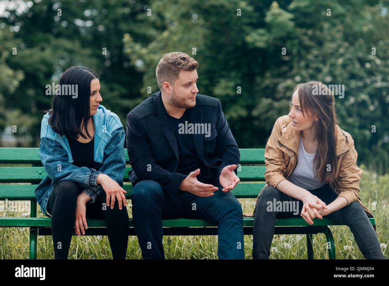 Conflicting people sitting bench talking Stock Photo - Alamy