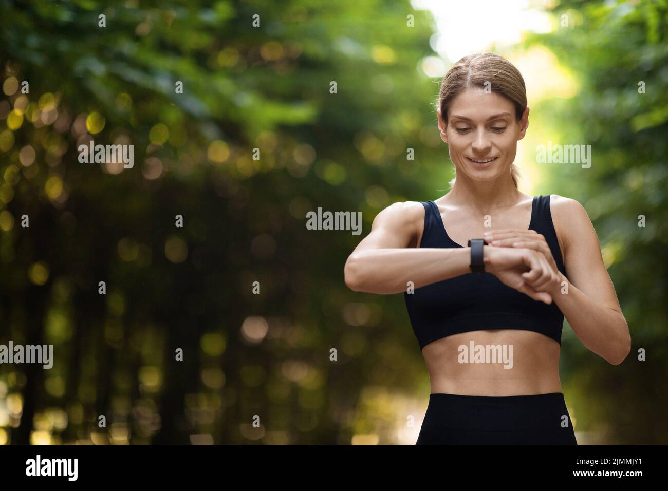 Athletic woman set her fitness tracker, copy space Stock Photo - Alamy