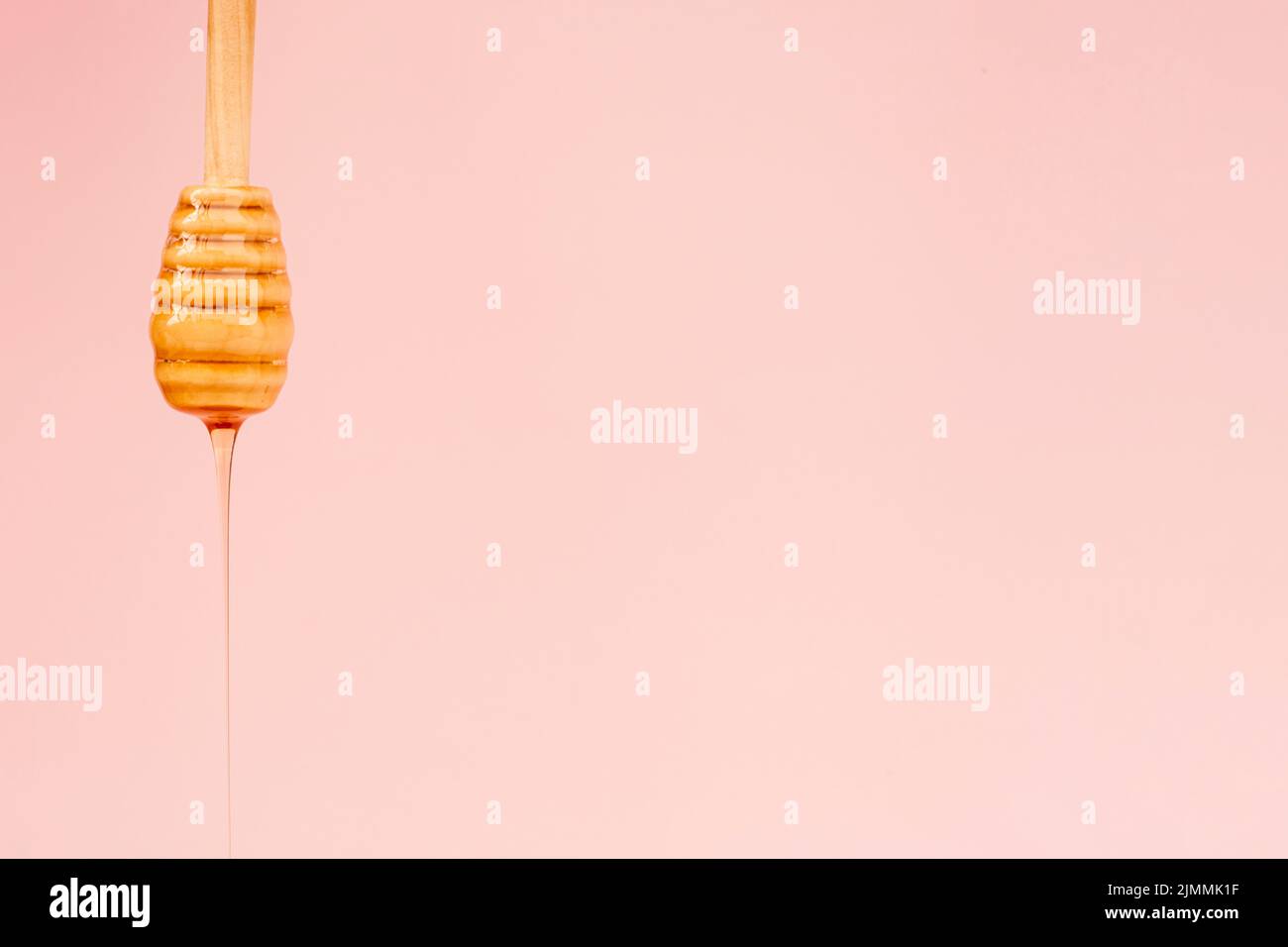 Close up tasty honey pouring from stick Stock Photo - Alamy