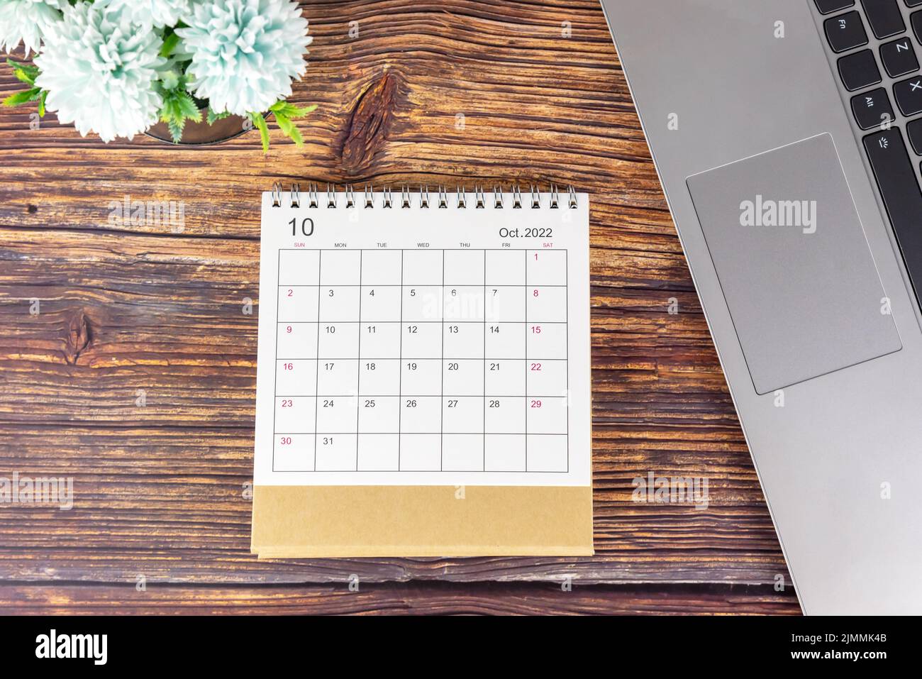 October 2022 desk calendar on wooden rustic table with laptop keyboard ...