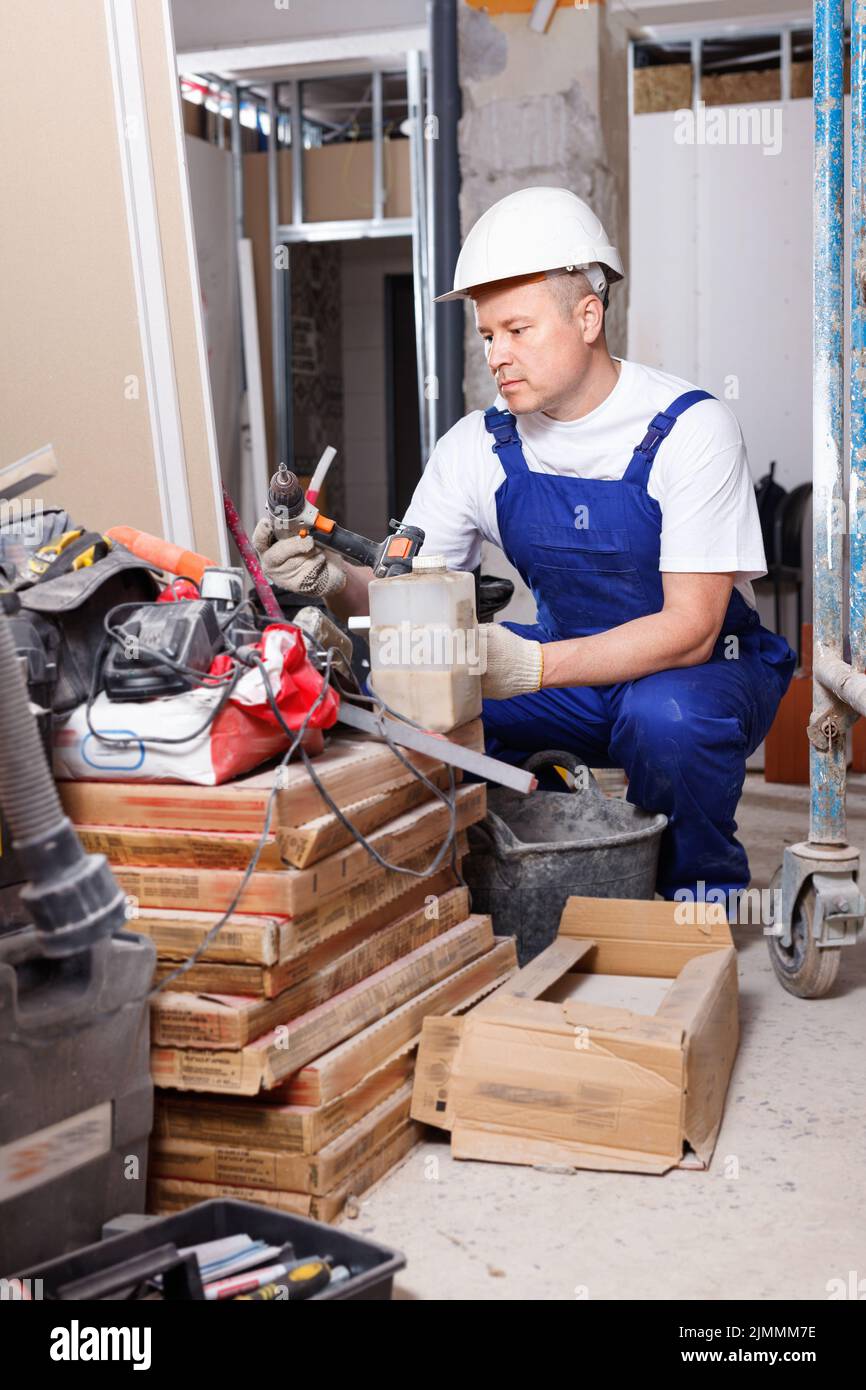 Professional builder checking tools and materials while getting ready ...