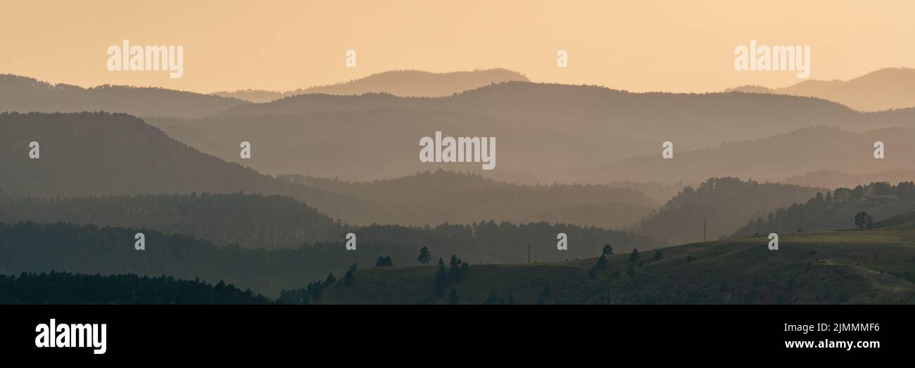 A panoramic shot of mountain silhouettes covered in thin fog Stock ...