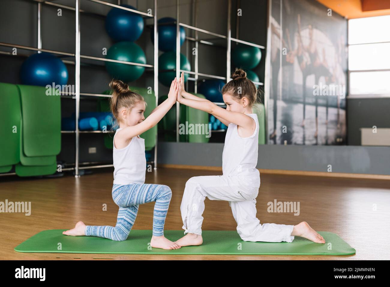 Two girl child exercising together gym Stock Photo - Alamy