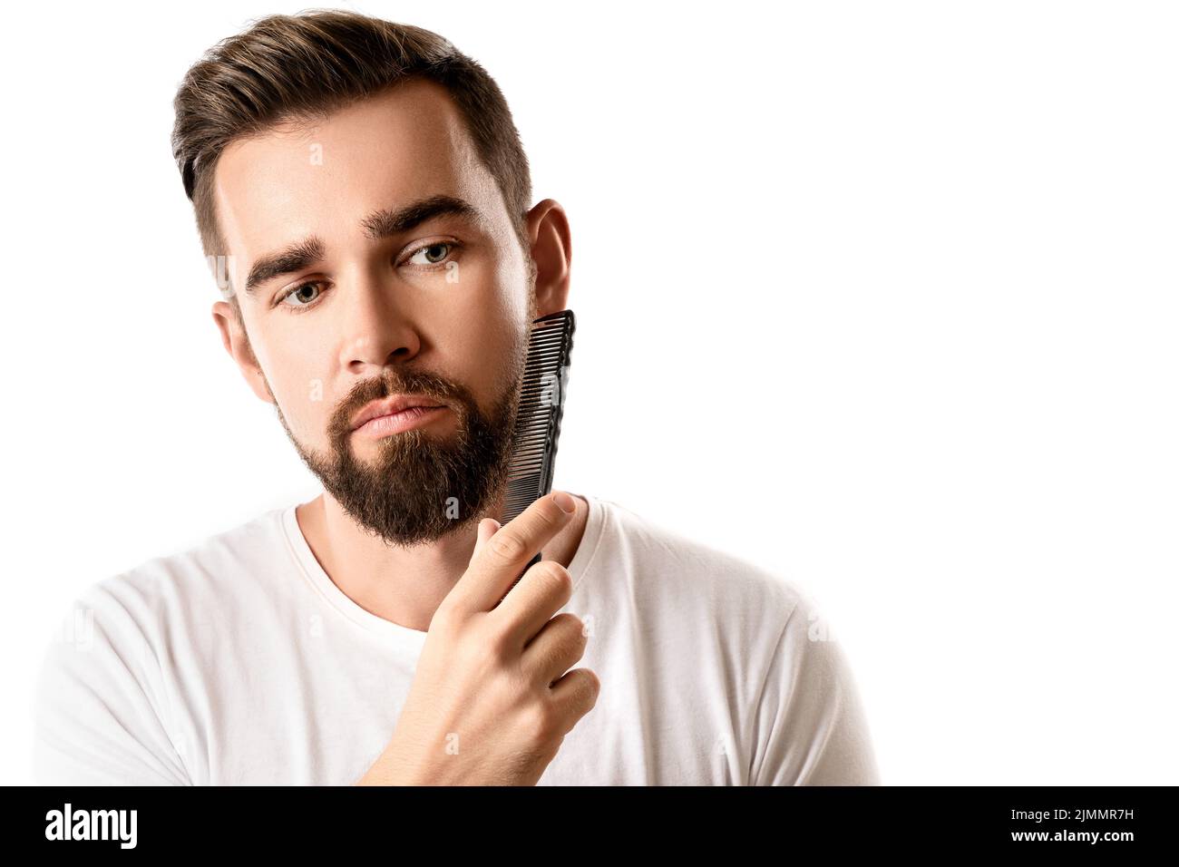 Handsome well groomed man combing his beard Stock Photo - Alamy