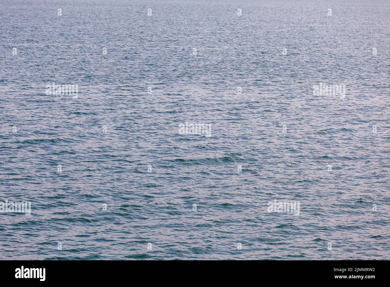 Blue turquoise transparent water surface of a sea with small waves ...