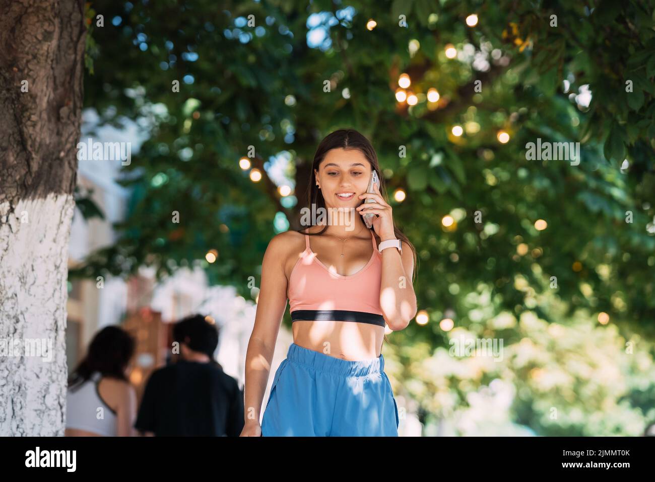 Attractive woman talking on mobile phone on a summer street Stock Photo ...