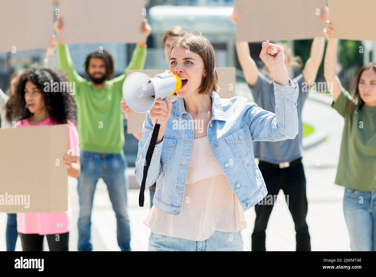 Front view woman with megaphone protesting street Stock Photo - Alamy