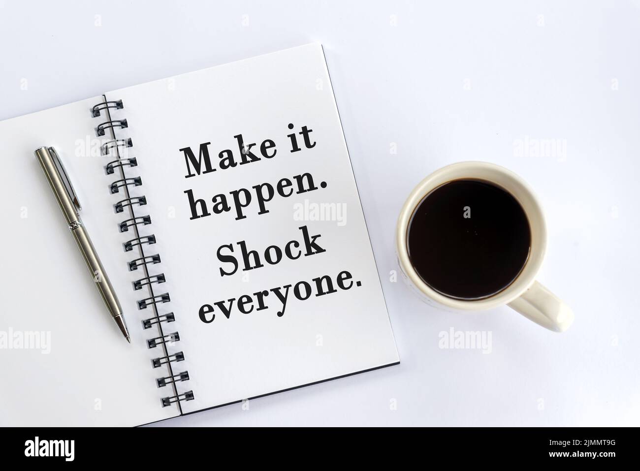 Positive motivational text message on a spiral notebook with pen and a ...