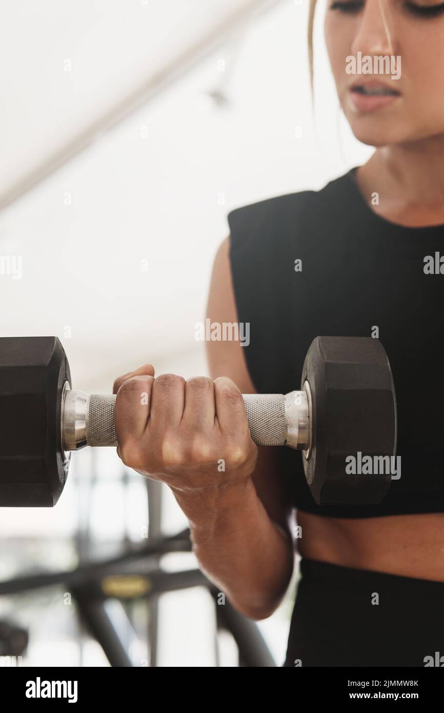 Female hand with a dumbbell during biceps curl exercise Stock Photo - Alamy