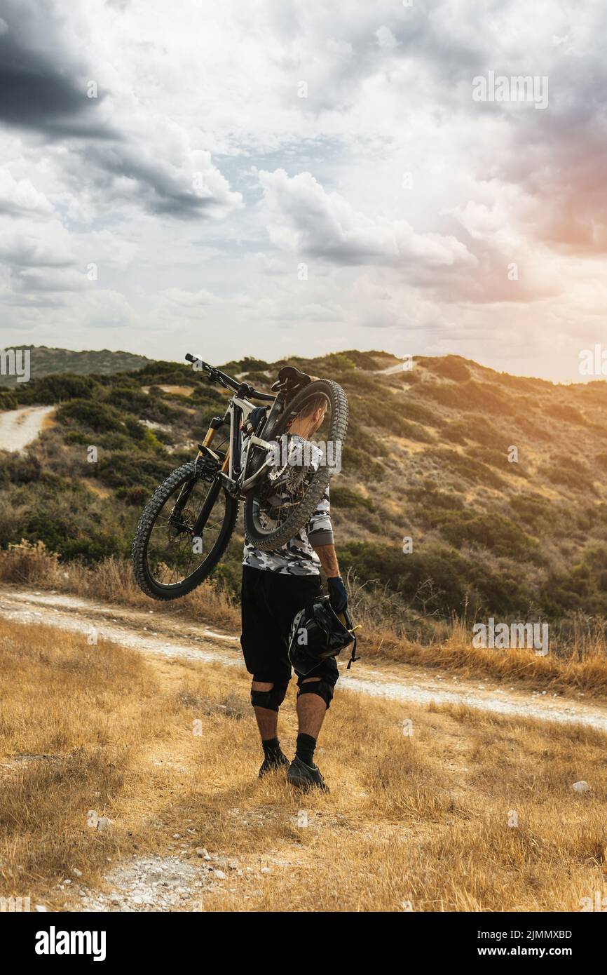 Professional downhill rider carrying his bicycle on shoulder Stock ...