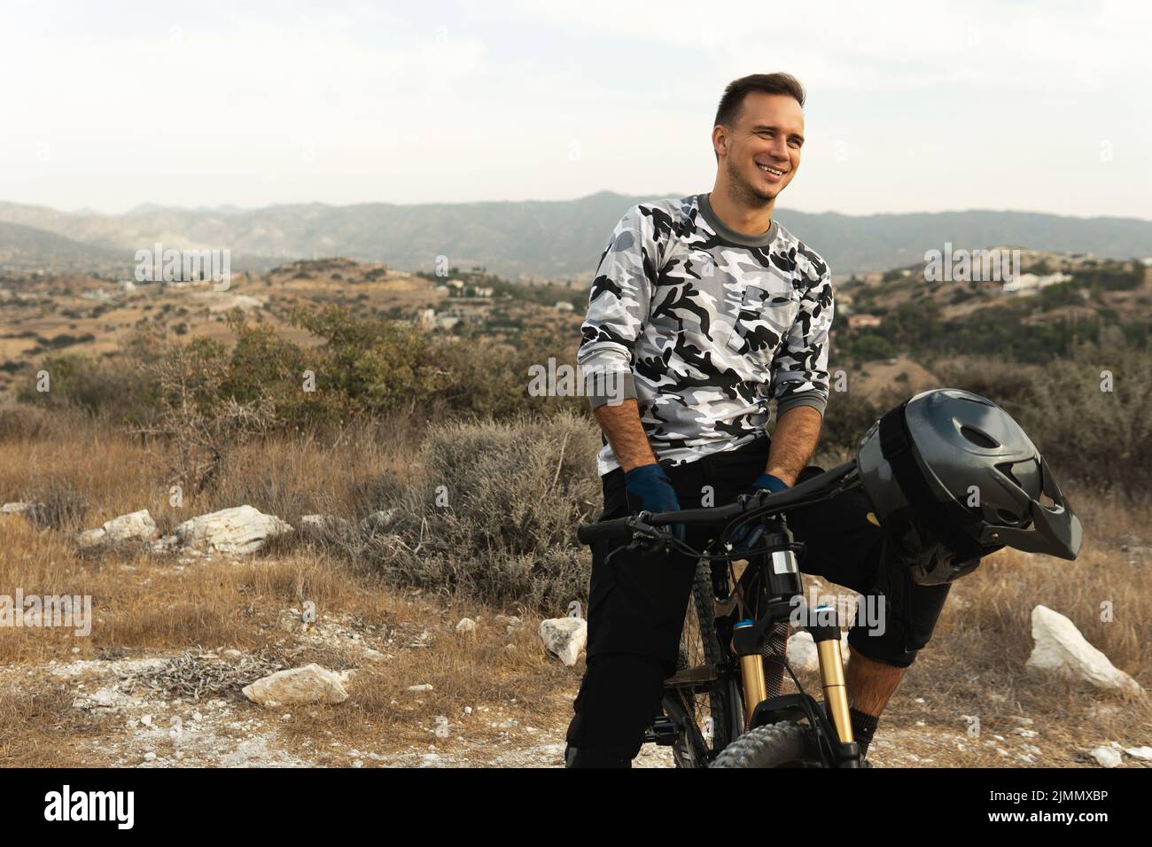 Smiling professional downhill rider and his bicycle Stock Photo - Alamy