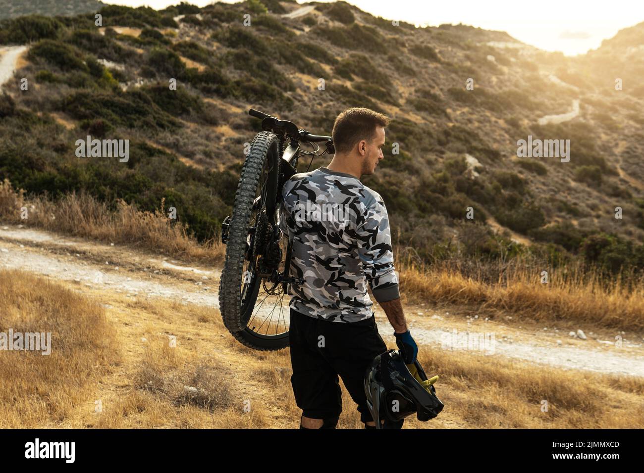 Professional downhill rider carrying his bicycle on shoulder Stock ...