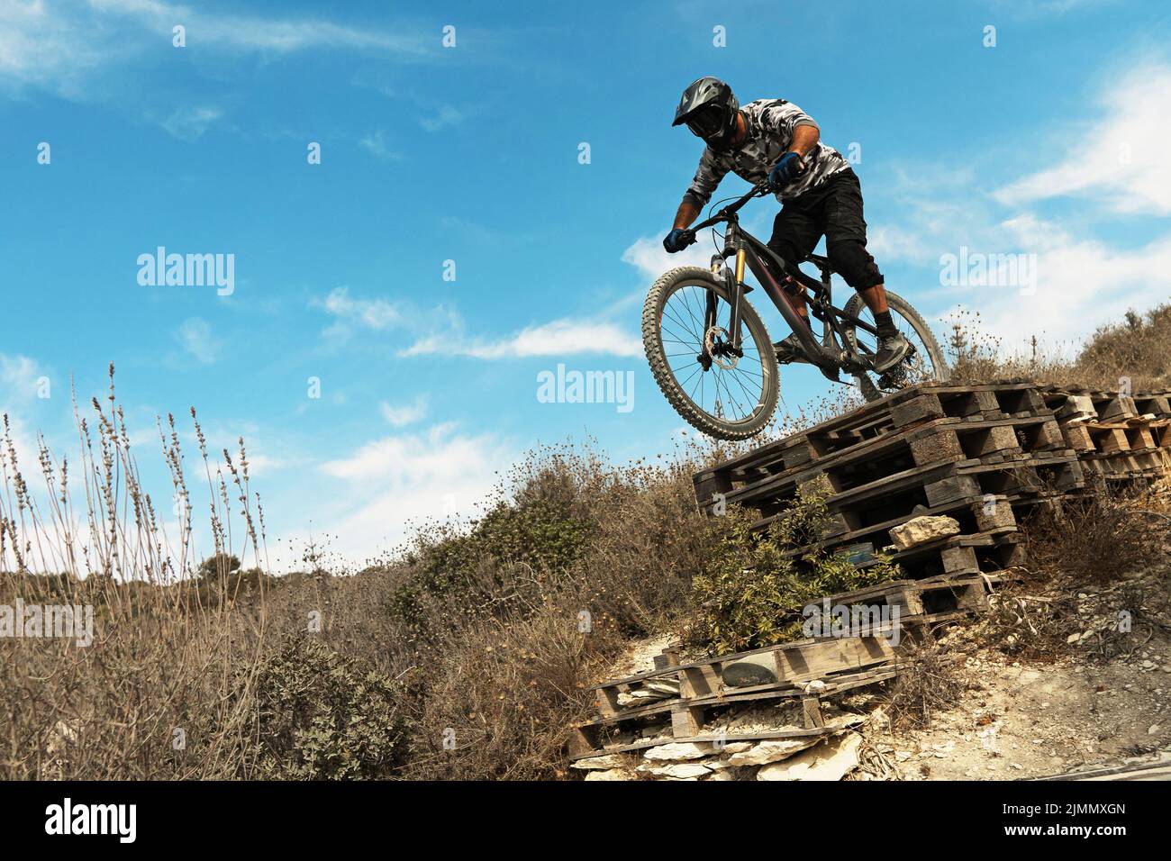 MTB bike rider jumping during downhill ride on his bicycle in mountains ...