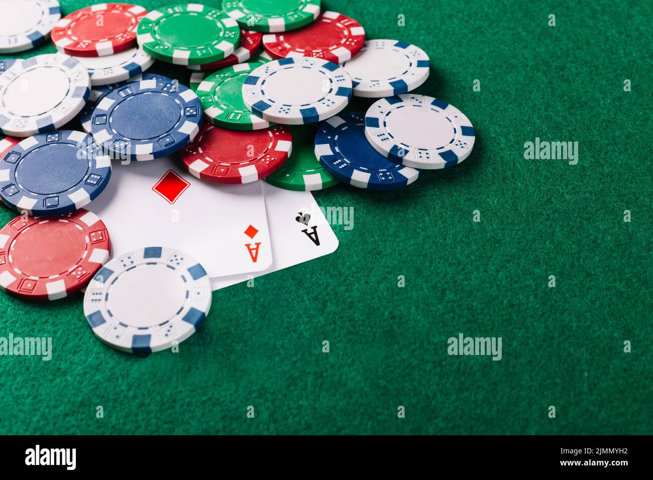 Two aces playing cards chips green backdrop Stock Photo - Alamy