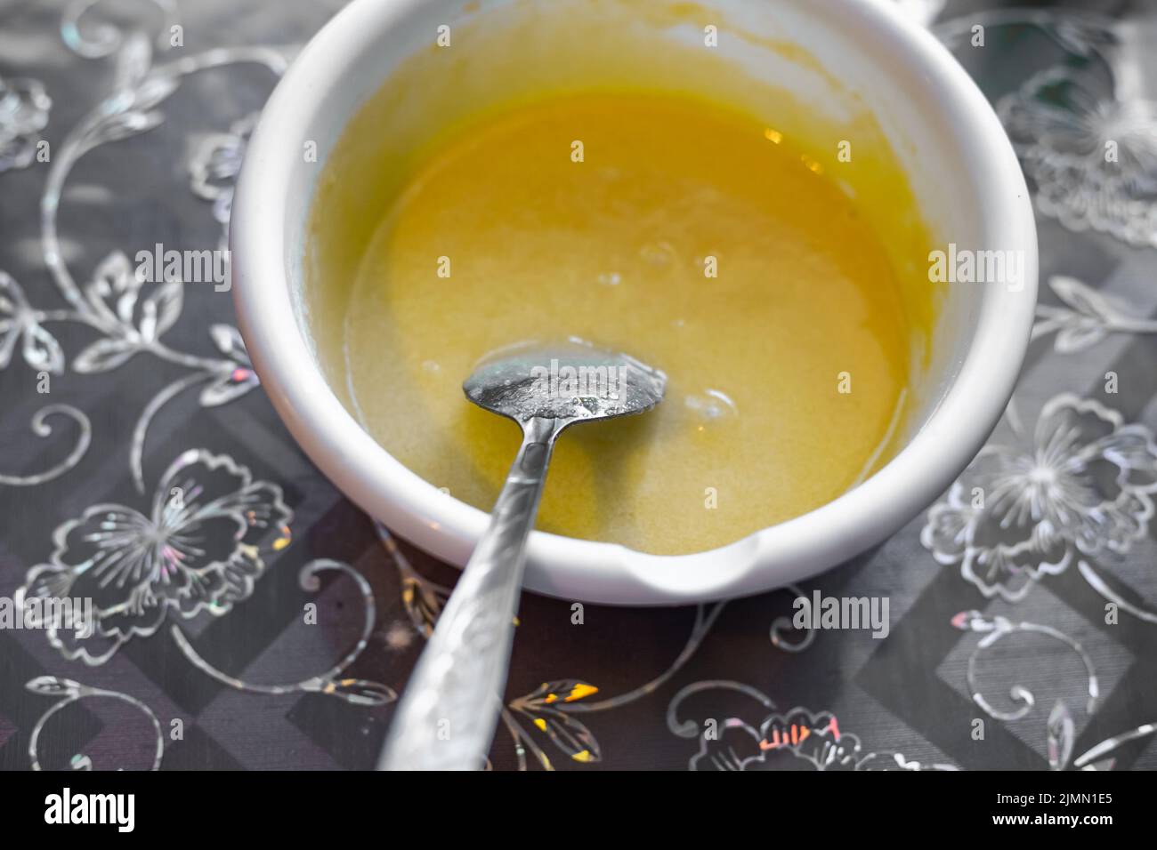 Cooking homemade cake. Iron spoon in custard for brushing the cake ...