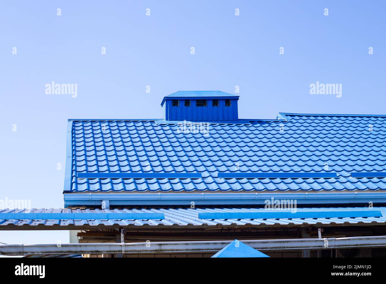 Blue metal roof against a blue sky. Construction and real estate Stock ...