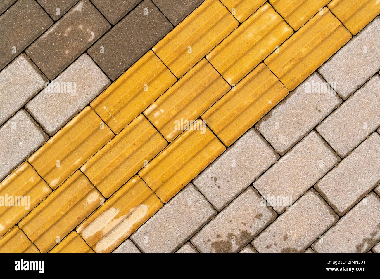 Sidewalk with yellow tactile paving Stock Photo - Alamy
