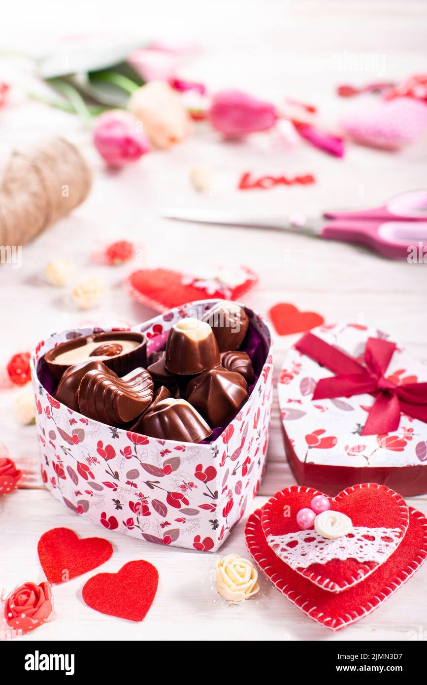 Chokolate box in shape of heart on white wooden table valentine ...