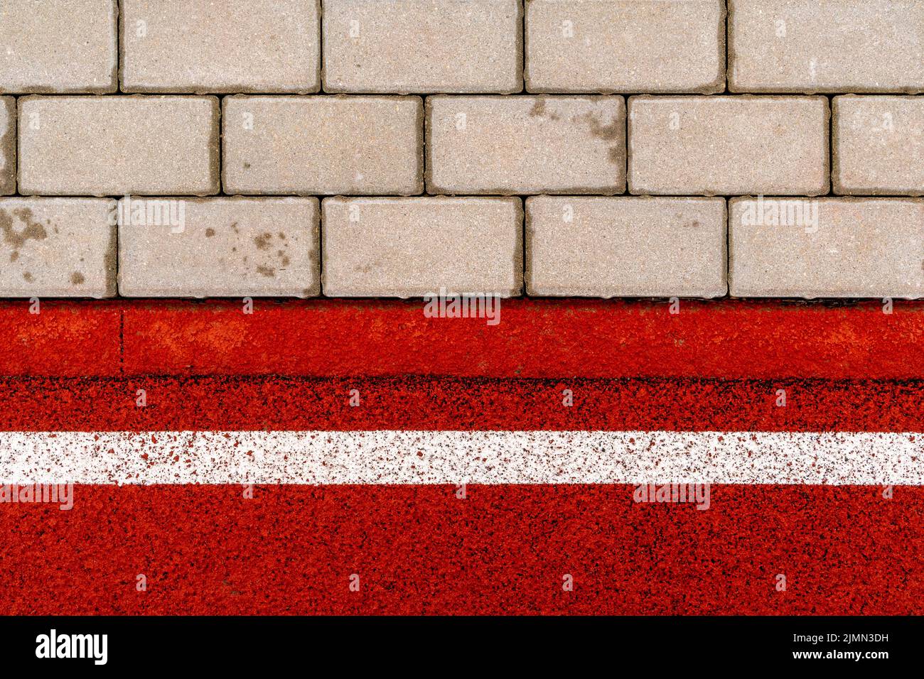 Red soft rubber matt jogging track and tile pavement Stock Photo - Alamy