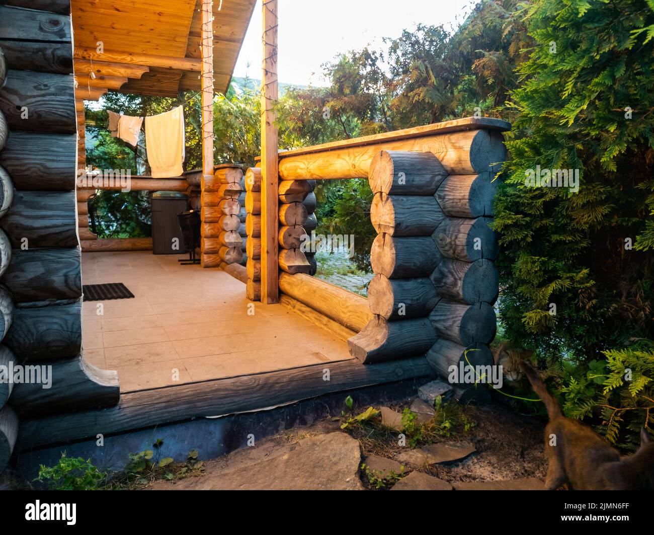 Rustic verandah of a rural log cabin or house with clean washing ...