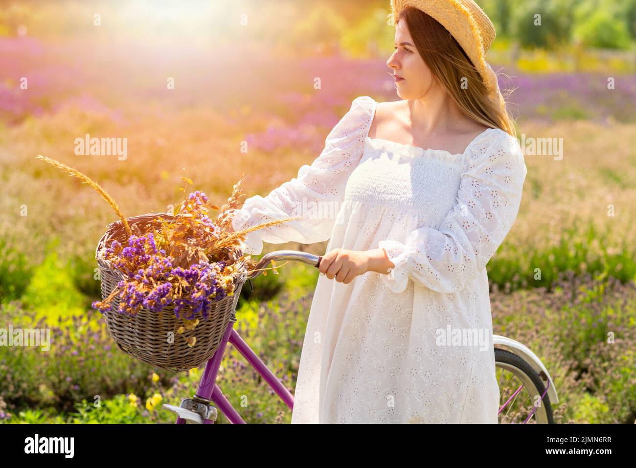 Soft focus high key portrait of a young woman at sunset standing in a ...