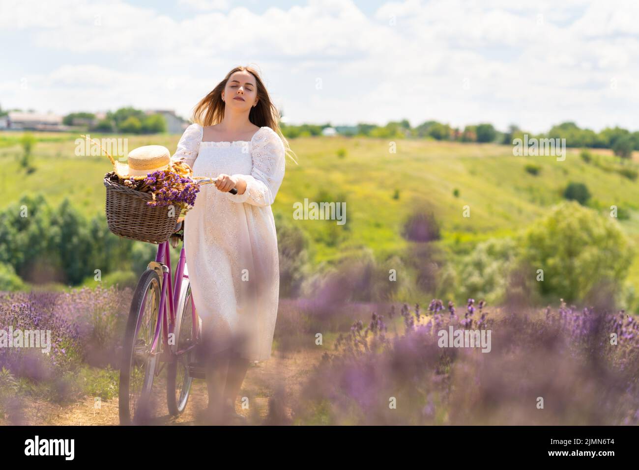 Serene young woman enjoying a day in the countryside wheeling her ...