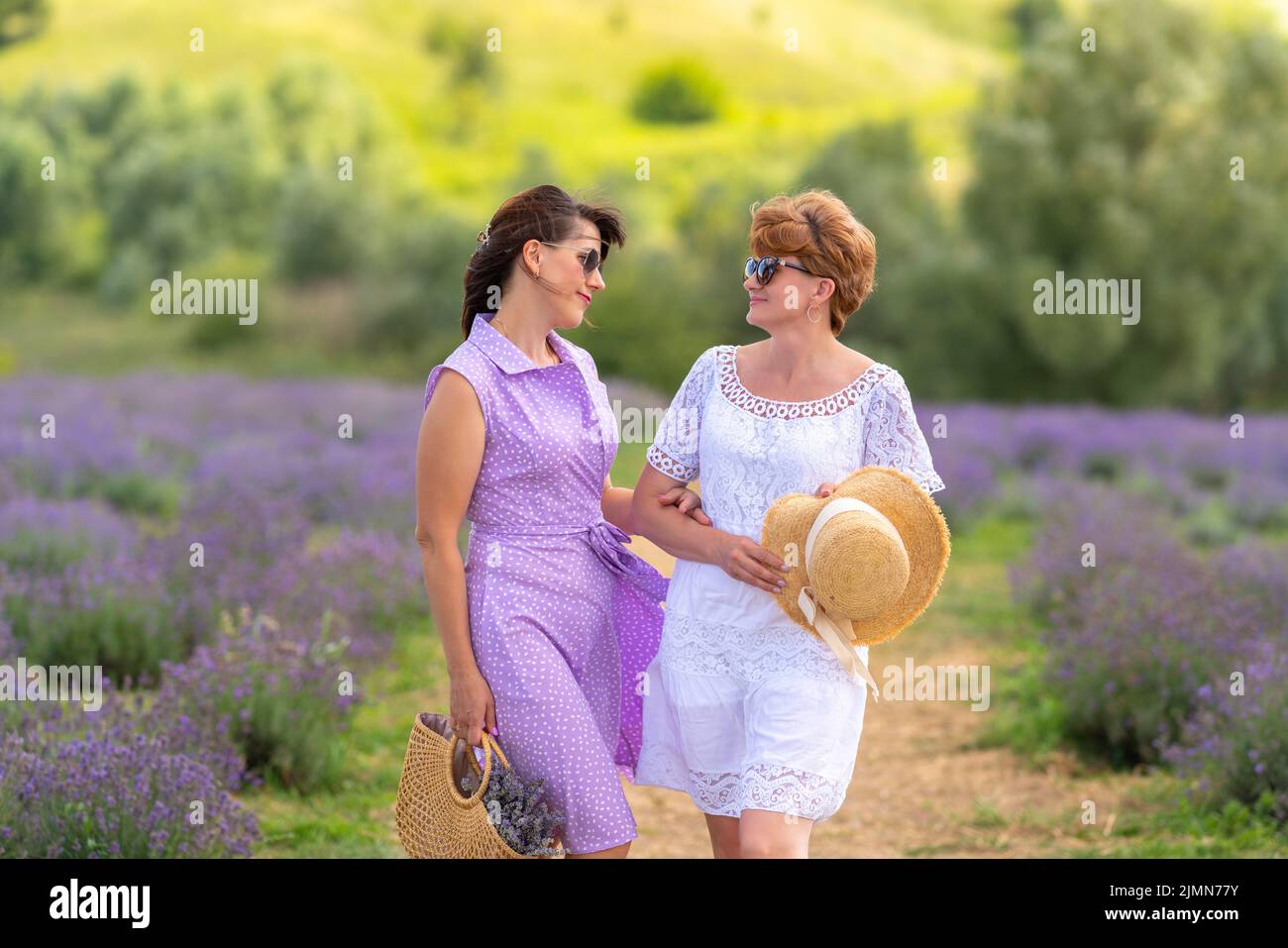 Two good women friends enjoying quality time together standing smiling ...