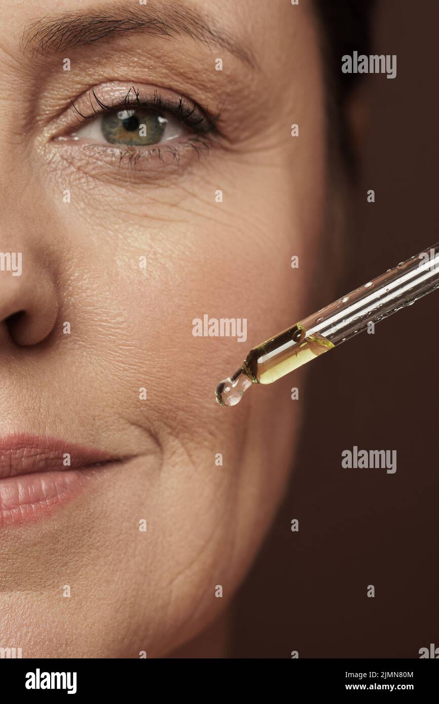 Female face and dropper with rejuvenating serum Stock Photo - Alamy