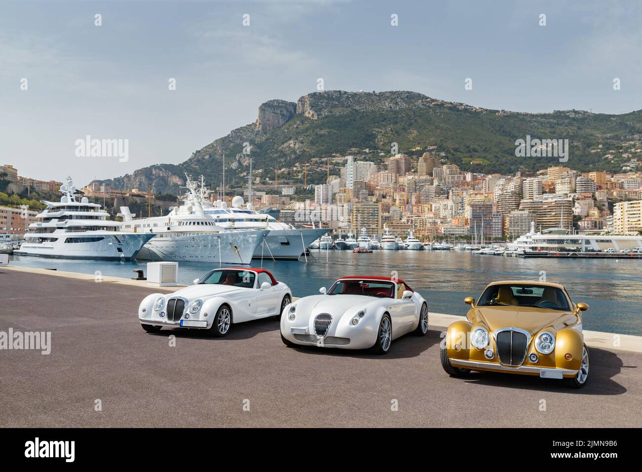 Exclusive expensive cars stand on the Monaco port pier overlooking the ...