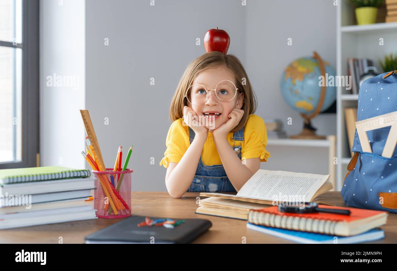 Back to school! Happy cute industrious child is sitting at a desk ...