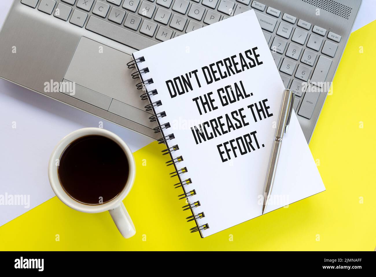 Business motivational words on a notebook - Don't decrease the goal. Increase the effort. A flat ...