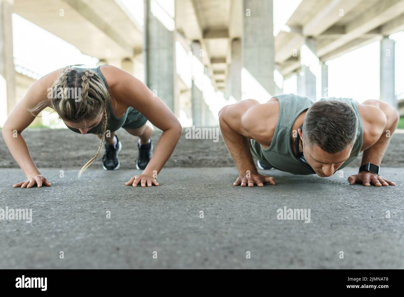 Athletic couple and fitness training outdoors. Man and woman doing push ...