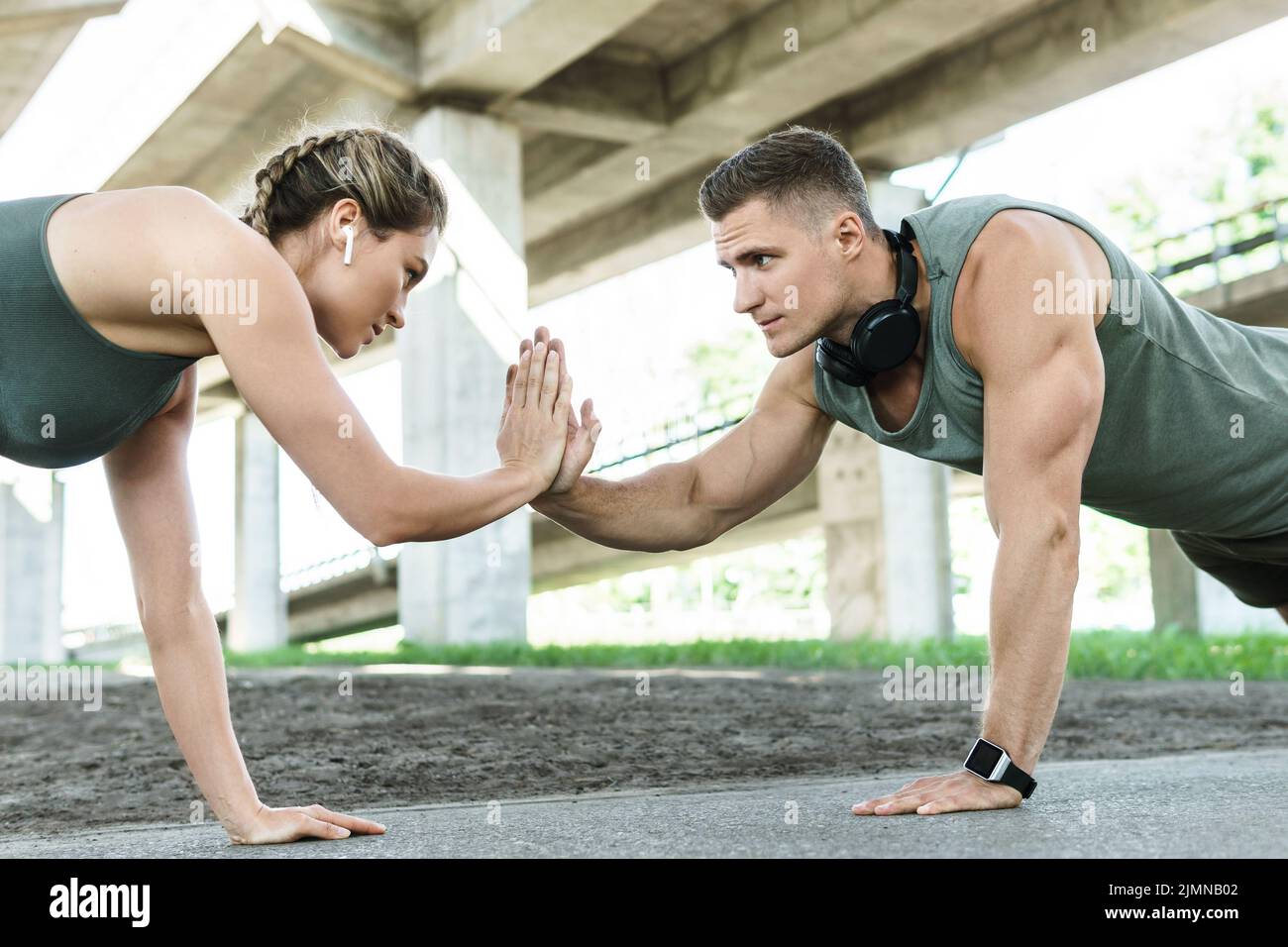 Athletic couple and fitness training outdoors. Man and woman doing push ...