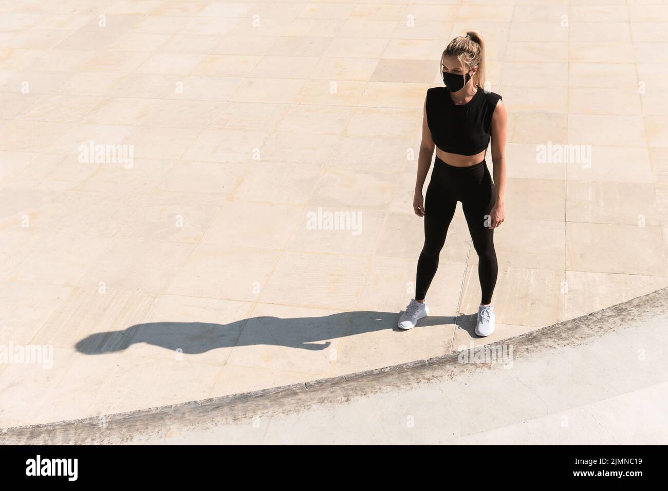 Athletic woman wearing face mask during summer street workout Stock ...