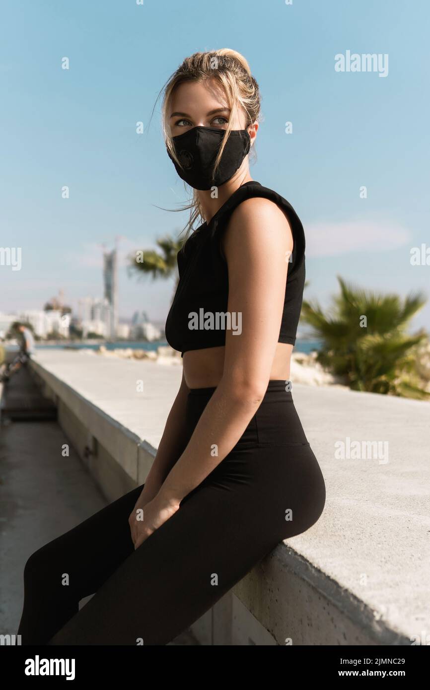 Athletic woman wearing face mask during summer street workout Stock ...