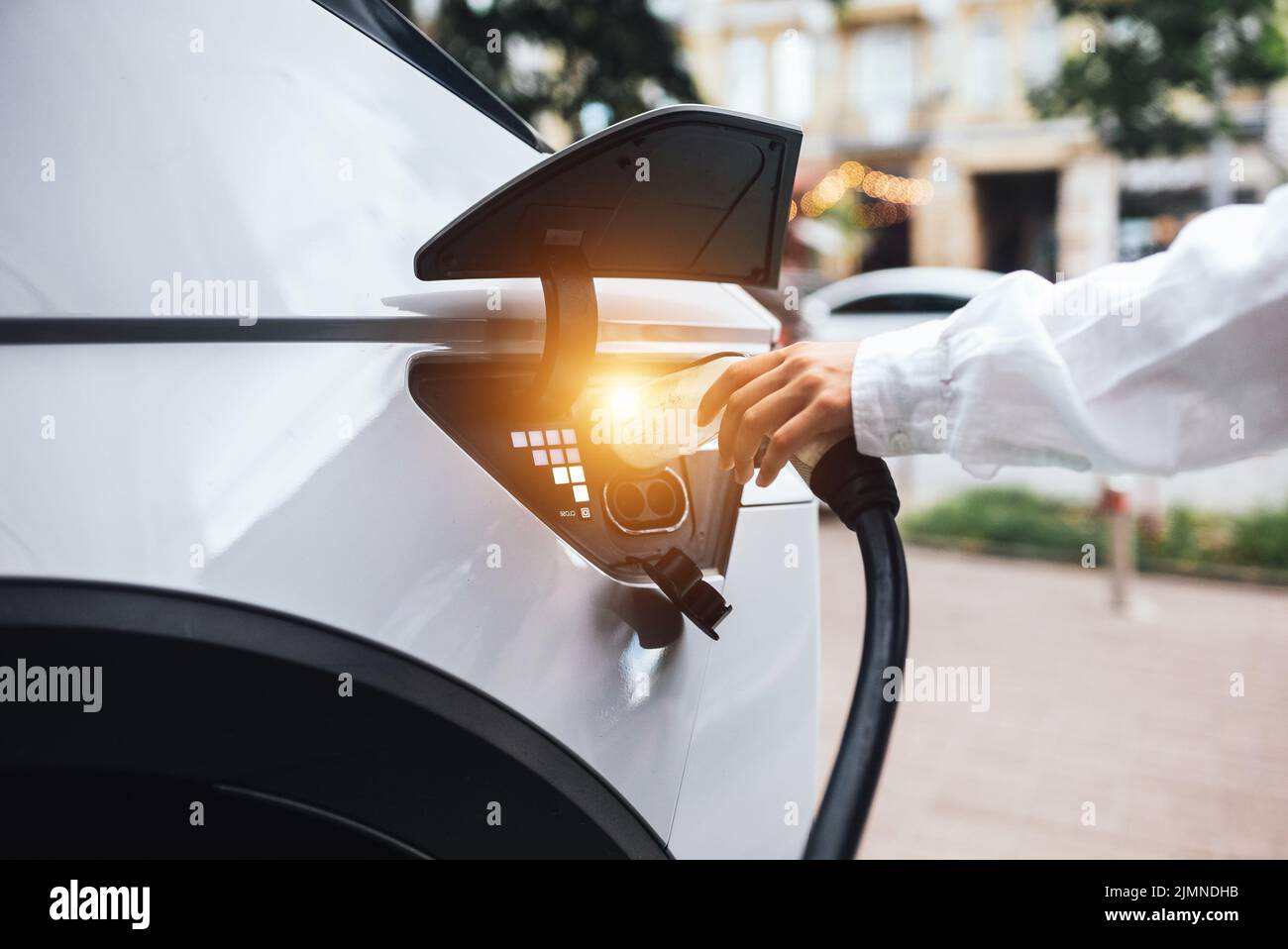 Human hand is holding Electric Car Charging nozzle Stock Photo - Alamy
