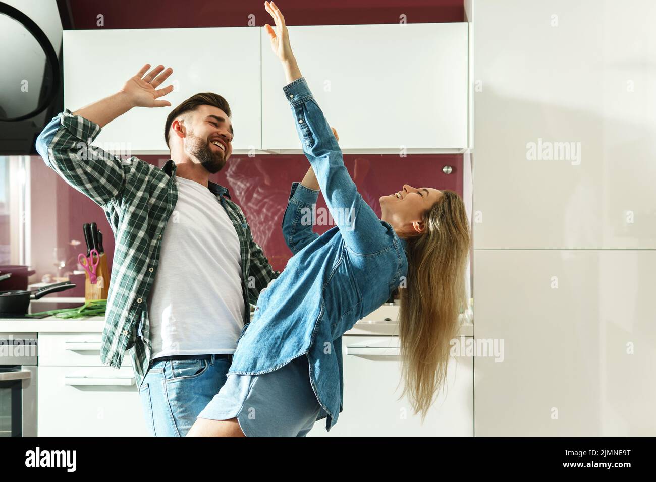 Couple dancing on the kitchen while cooking during sunny morning Stock ...
