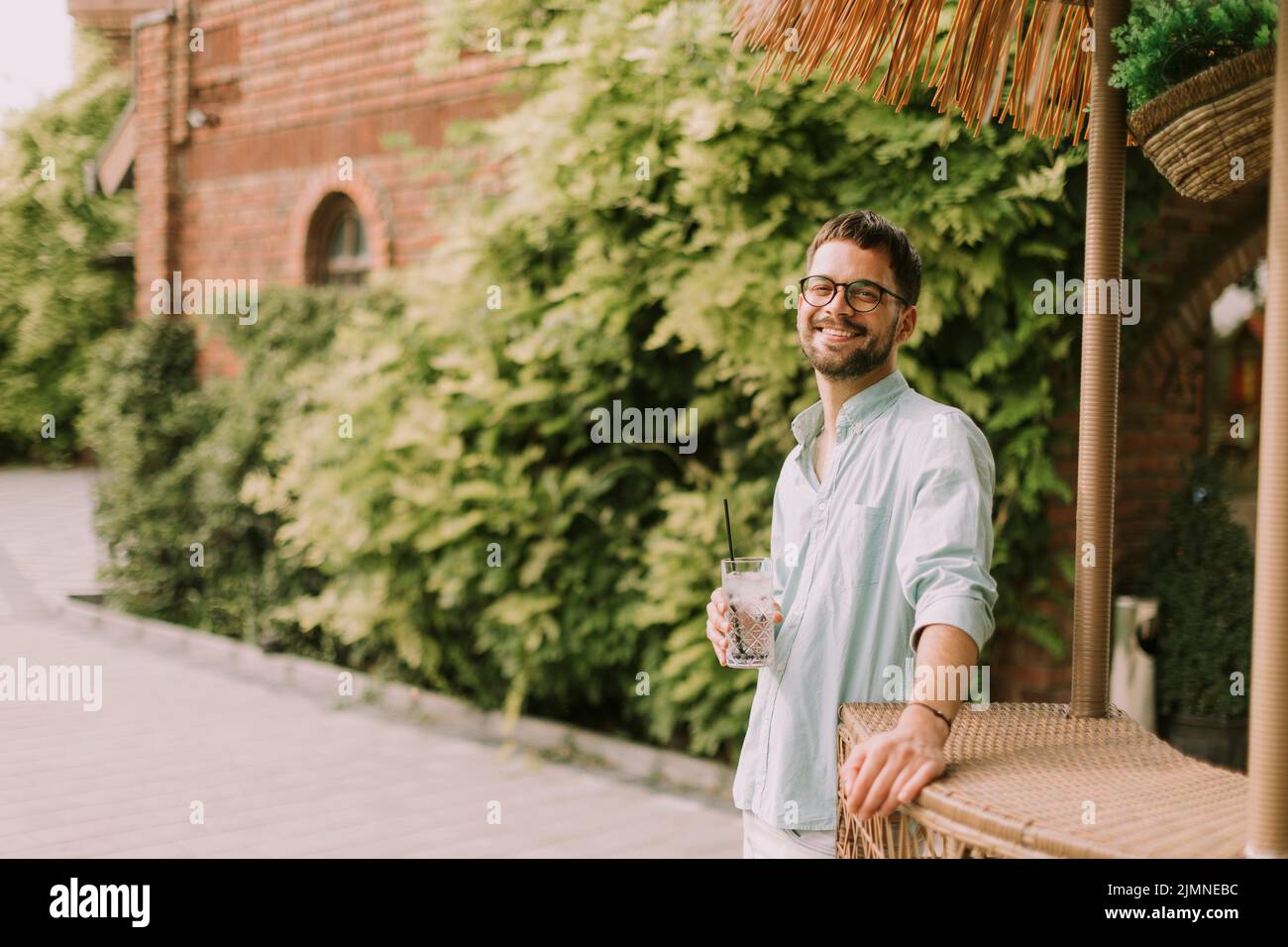 Handsome young man drinking fresh cold lemonade at the pool bar Stock ...