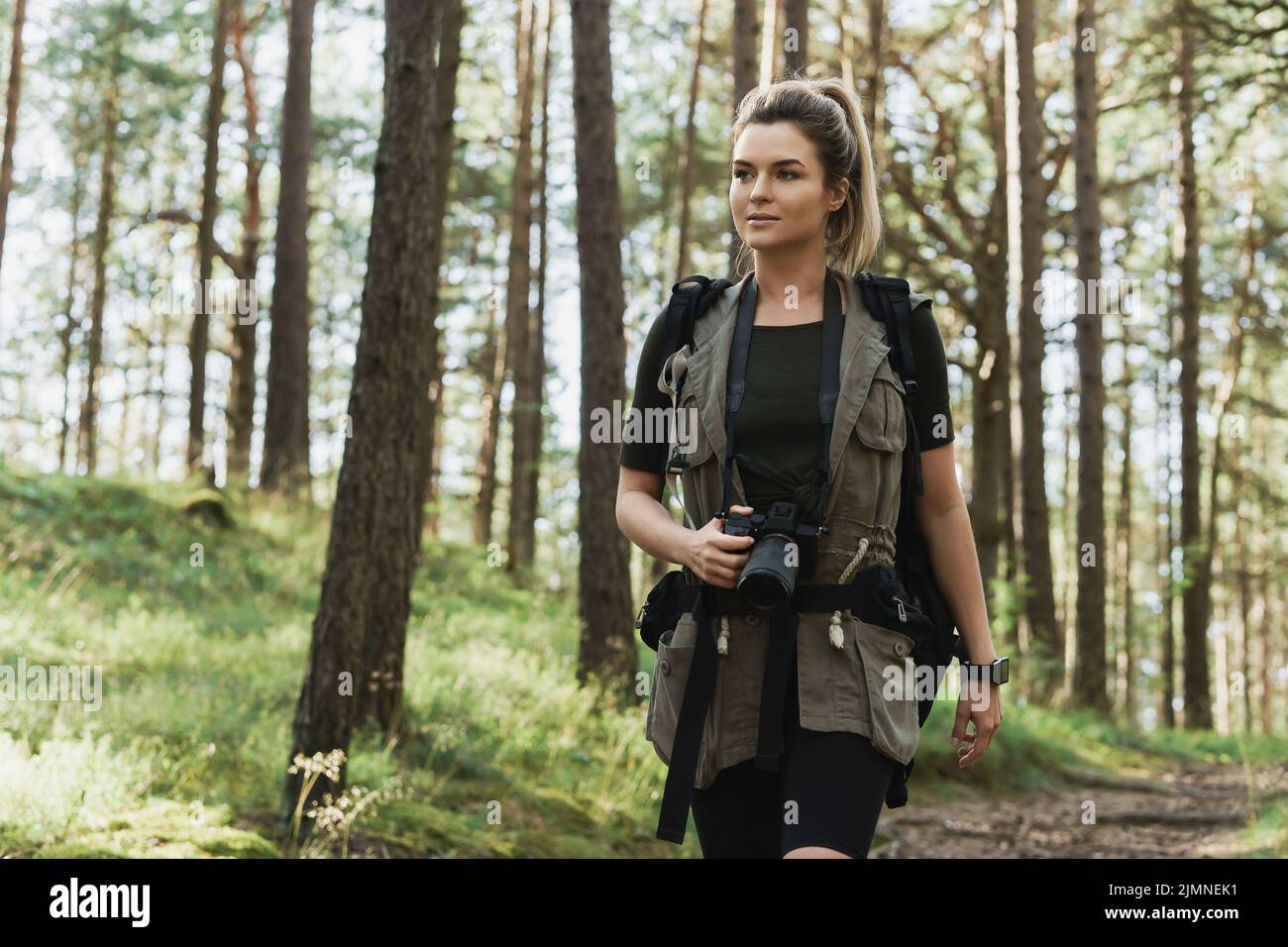Woman hiker walking with a backpack and modern mirrorless camera Stock ...