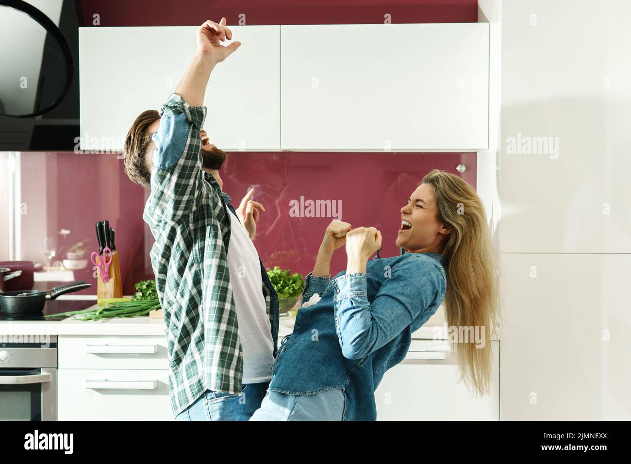 Couple dancing on the kitchen while cooking during sunny morning Stock ...