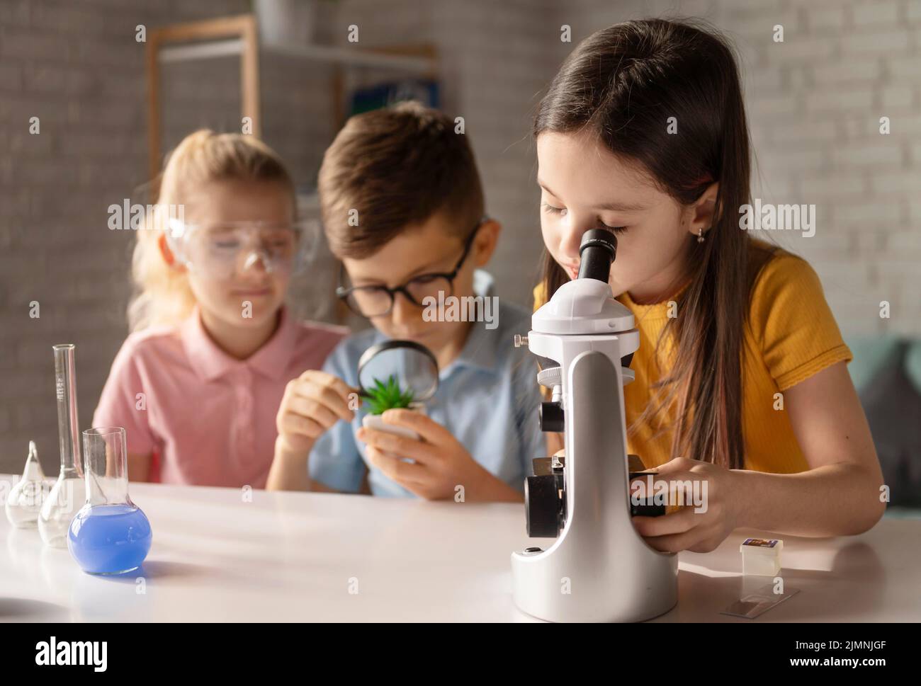 Medium shot kids working table Stock Photo - Alamy